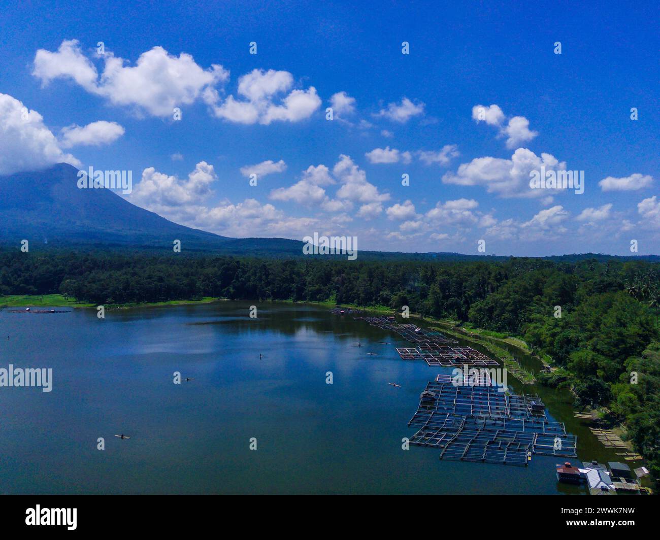 An aerial view of a clear blue lake with a dramatic, clouds capped ...