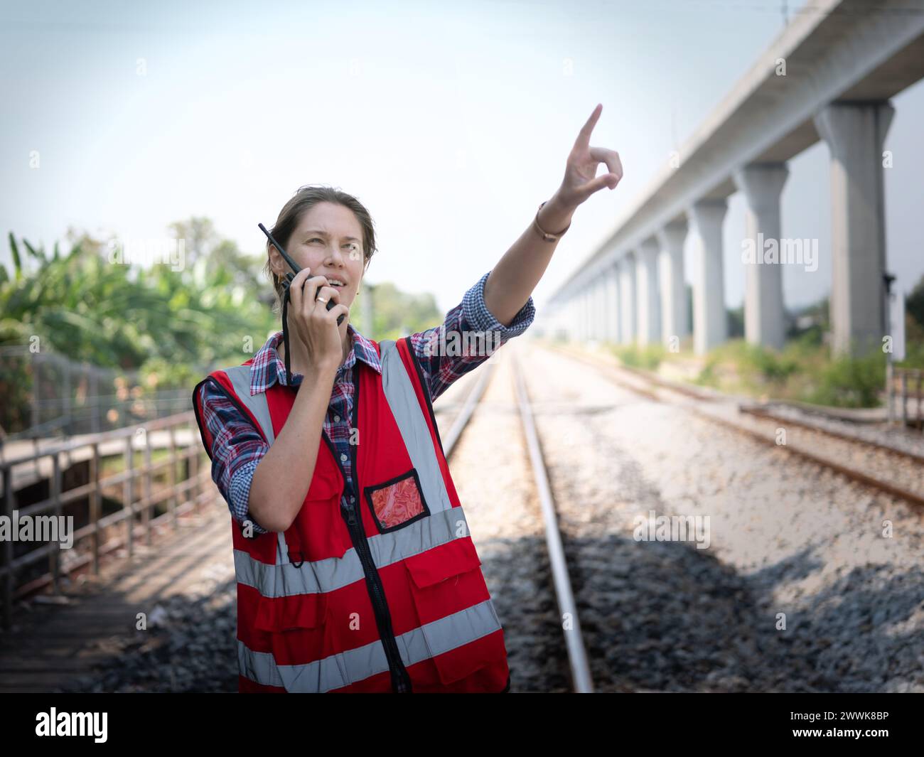 Woman railway engineer use walkie-talkie talking in to talk to ...