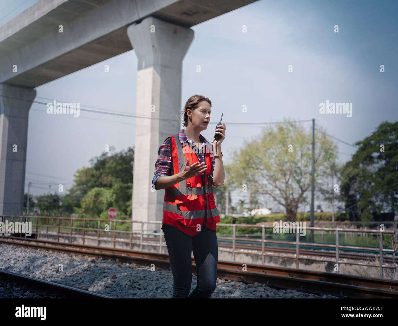 Woman railway engineer use walkie-talkie talking in to talk to ...