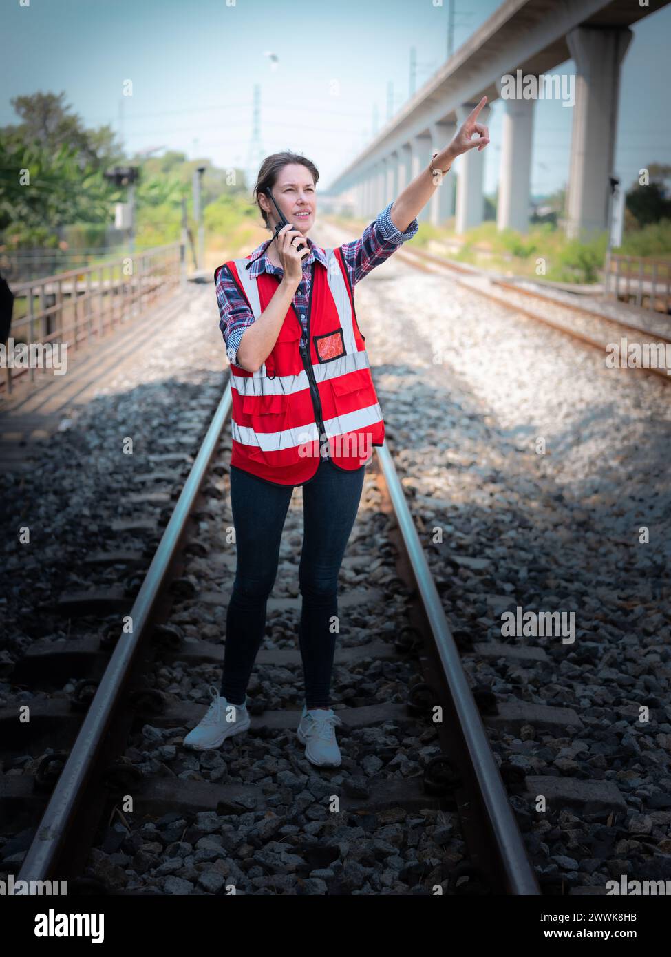 Woman railway engineer use walkie-talkie talking in to talk to ...
