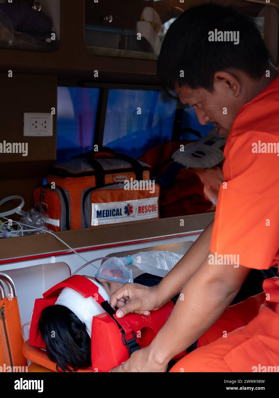 The paramedics used first aid and put on a breathing mask for a patient ...