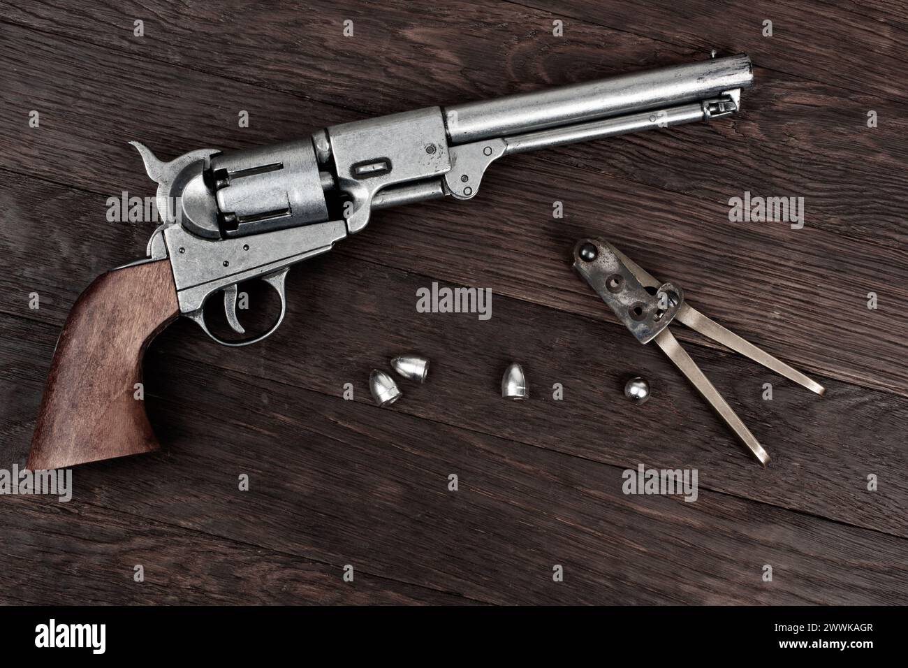 Old West Revolver with bullet mold and bullets on wooden background ...