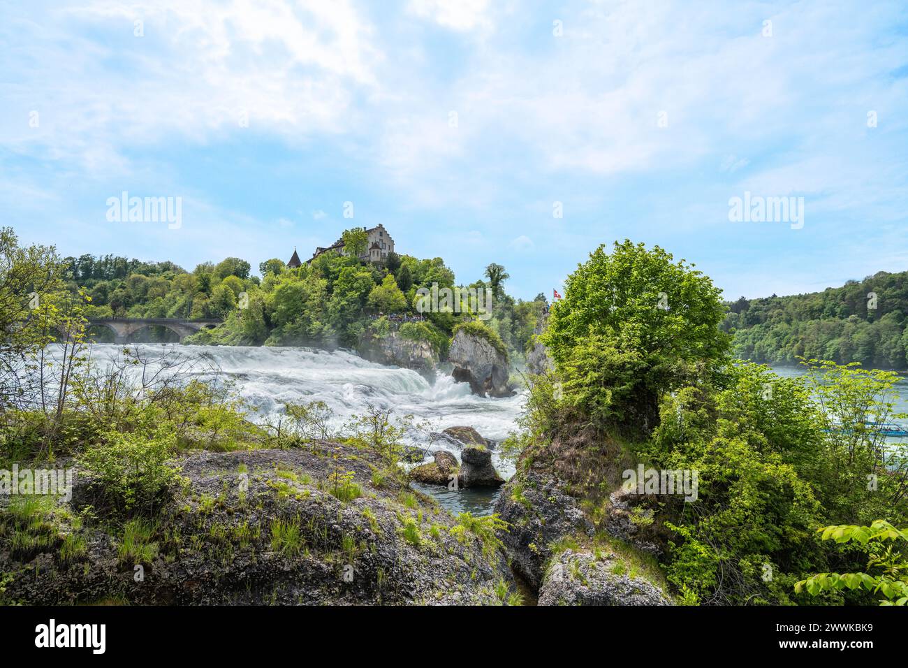 Description: Tourists watch the massive waterfalls below Laufen Castle ...