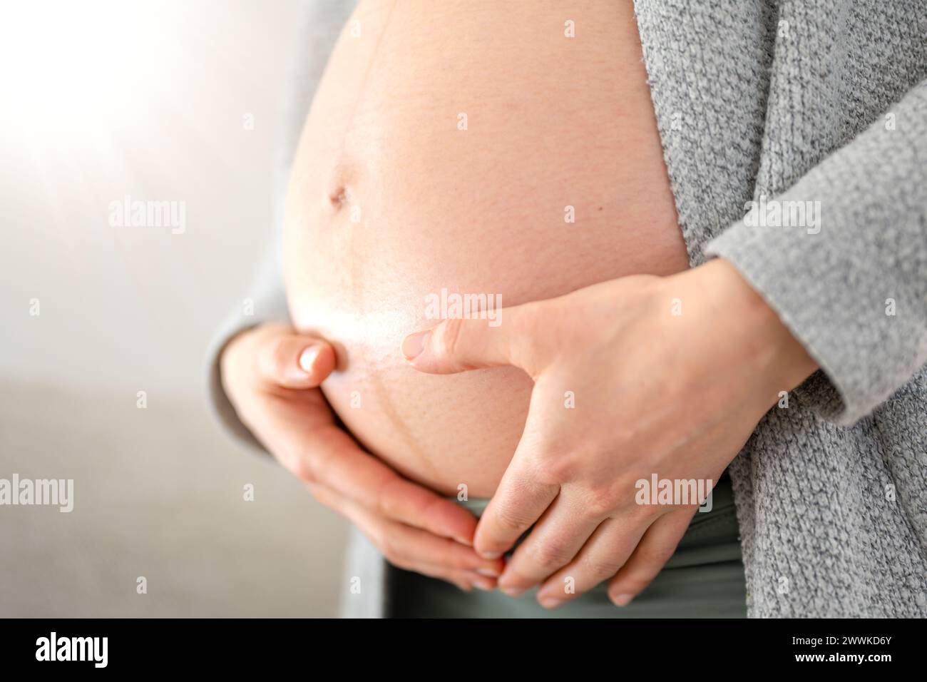 Description: Lateral view of midsection of unrecognizable woman gently ...
