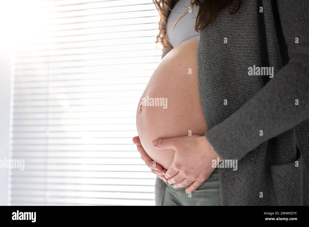 Description: Lateral view of midsection of unrecognizable woman gently ...