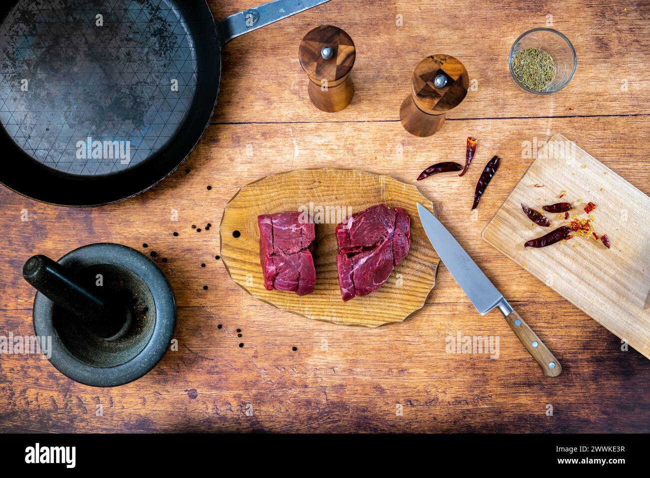 Description: Preparation of raw beef fillet steak on wooden board with ...