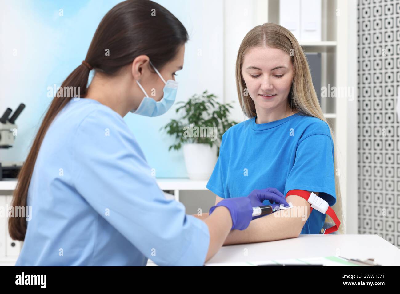 Laboratory testing. Doctor taking blood sample from patient at white ...