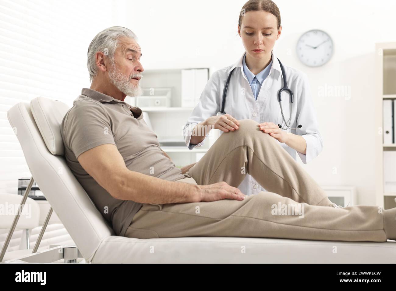 Arthritis symptoms. Doctor examining patient with knee pain in hospital ...