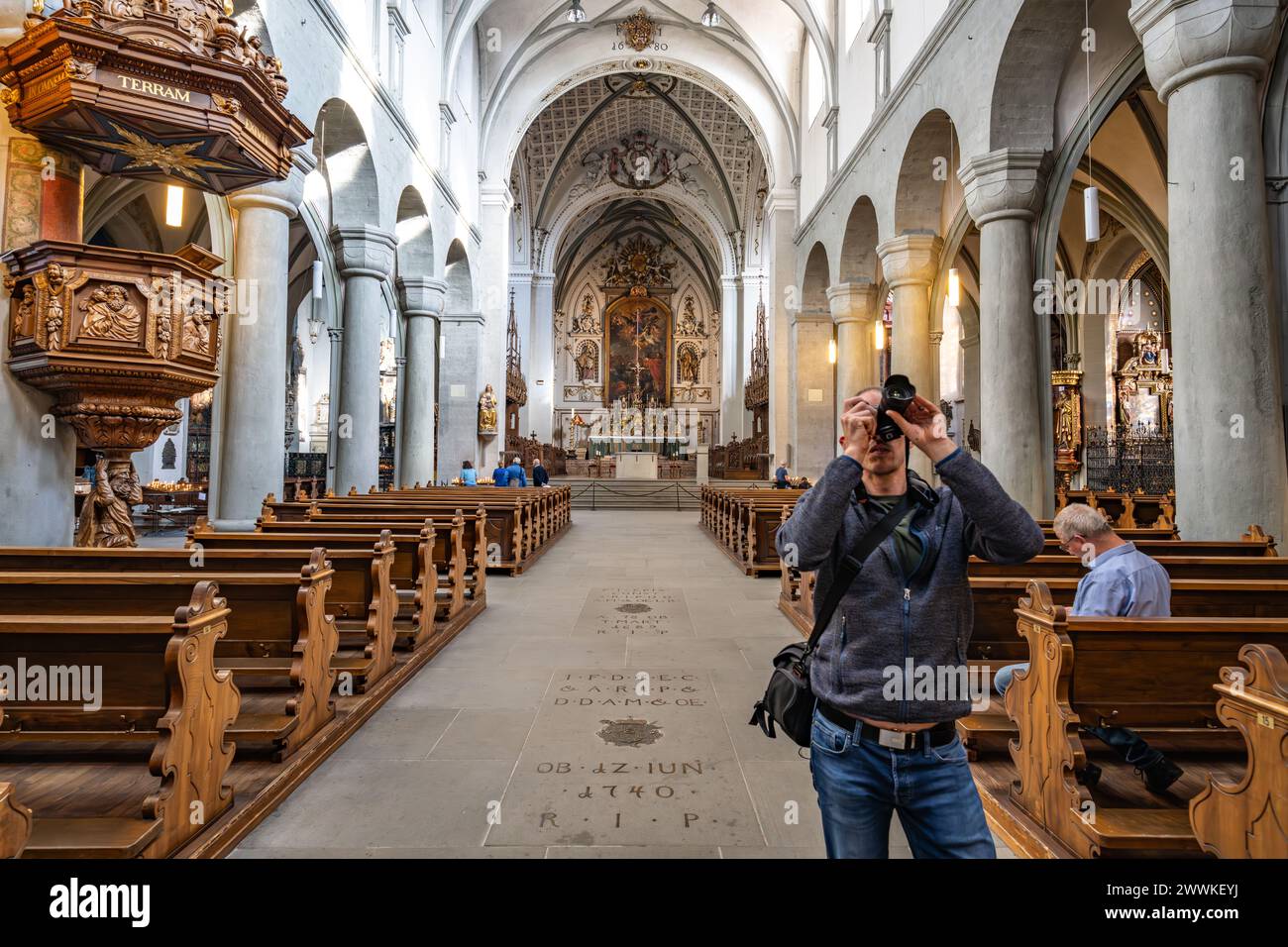 Description: Tourist photographs ceiling of the brightly lit Romanesque ...
