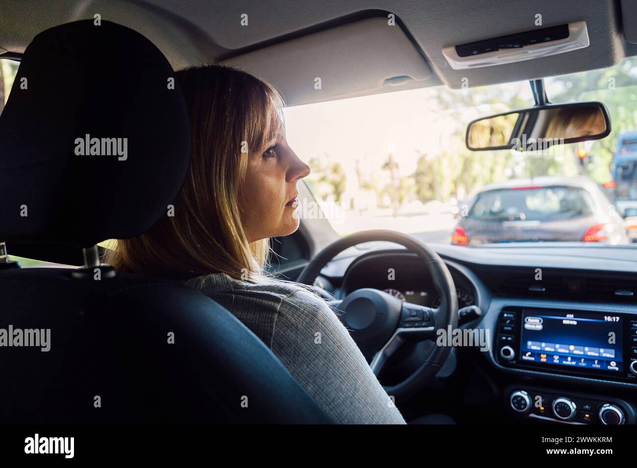 Woman in a car looking thoughtfully. Interior view Stock Photo - Alamy