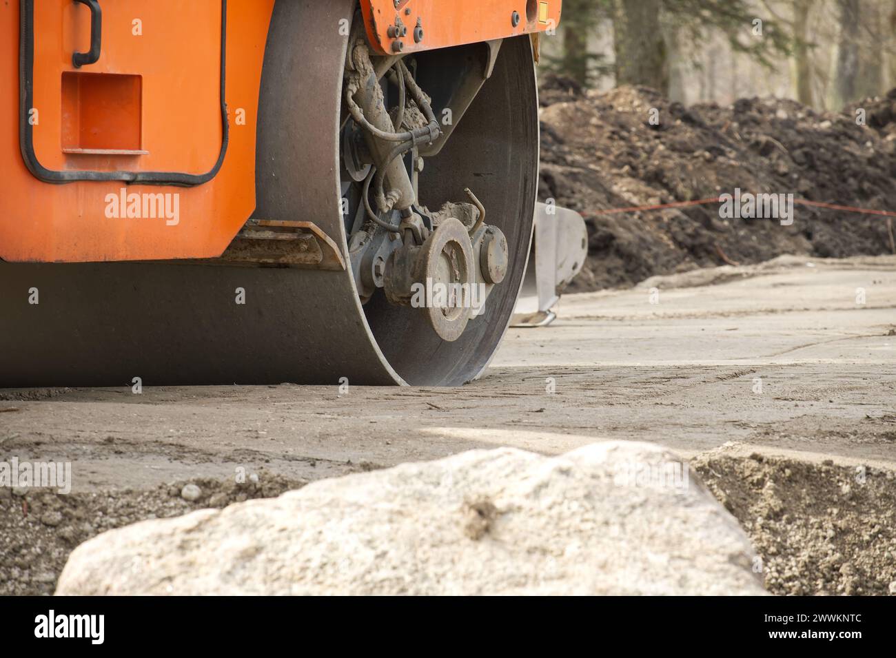 Orange road roller engaged in construction work, process of asphalt ...