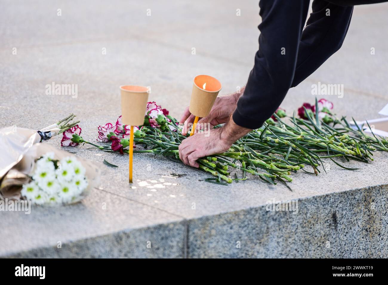 Melbourne, Australia. 24th Mar, 2024. A man lays flowers and place ...