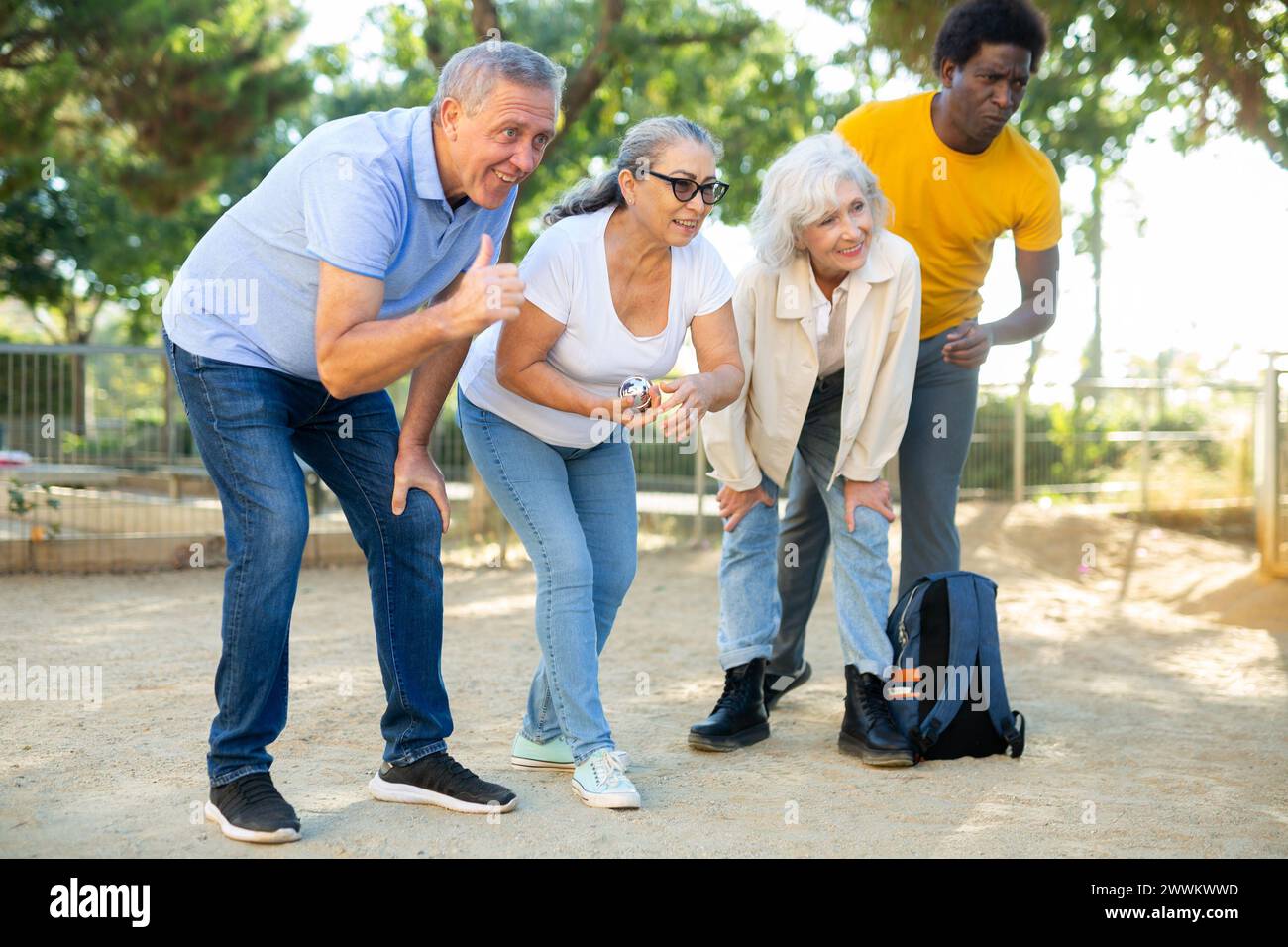 Positive multiracial mature people playing petanque game outdoors in ...