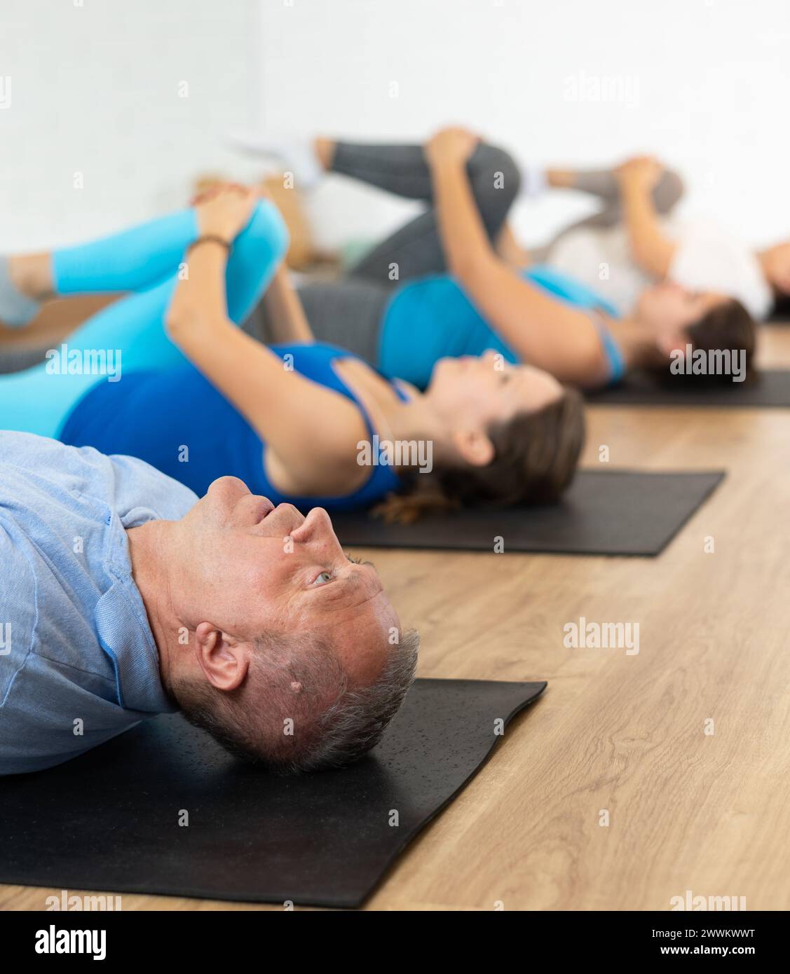 Old man practicing pilates on mat in gym area Stock Photo - Alamy
