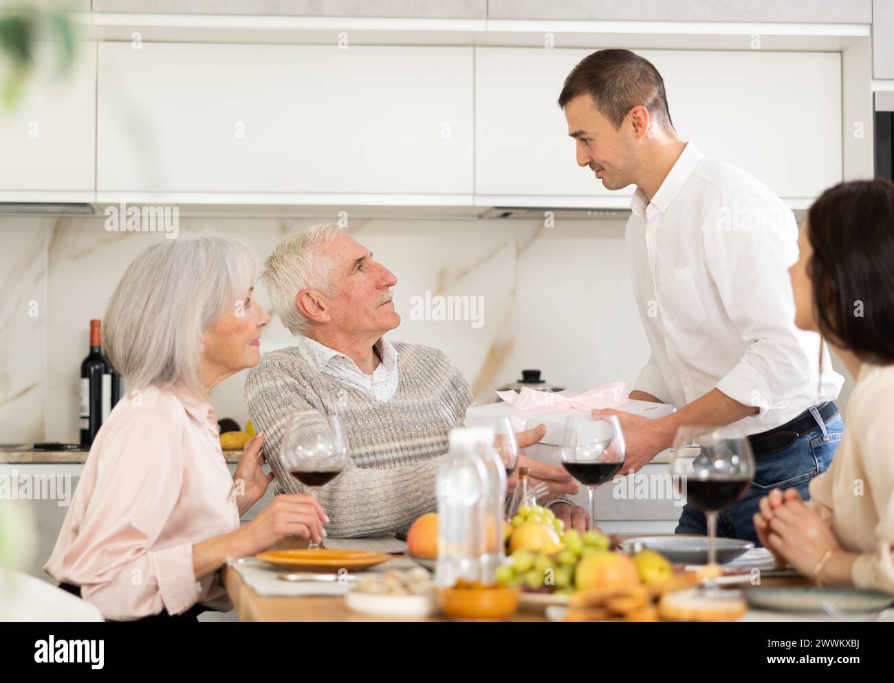 Birthday senior man accepts outright gift and greetings from adult son ...