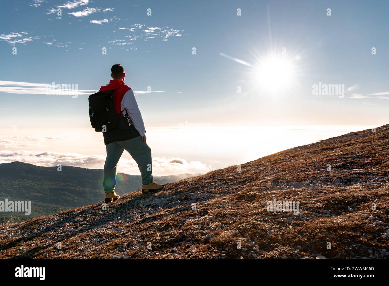 Hiker tourist with backpack is standing high in mountains above the ...