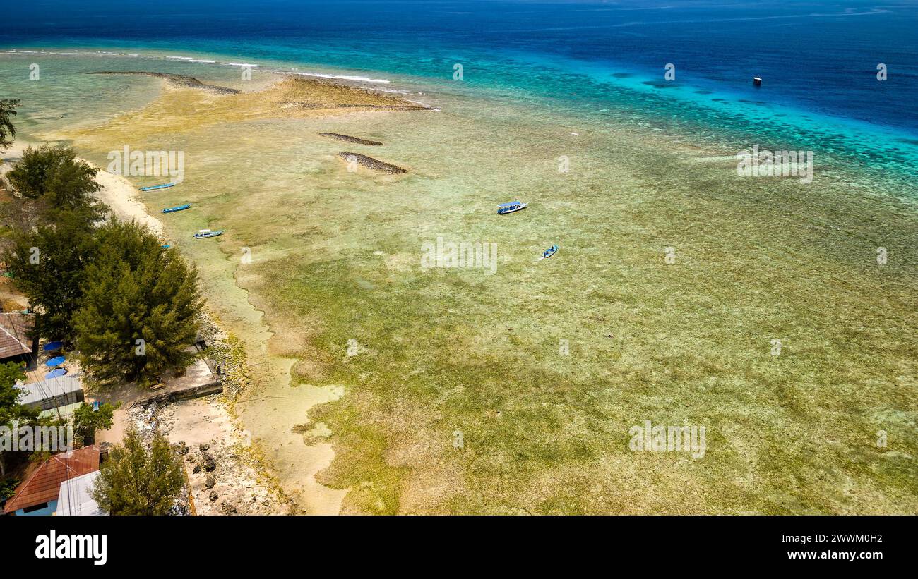Aerial view of a huge coral reef table forming a fringing reef around a ...