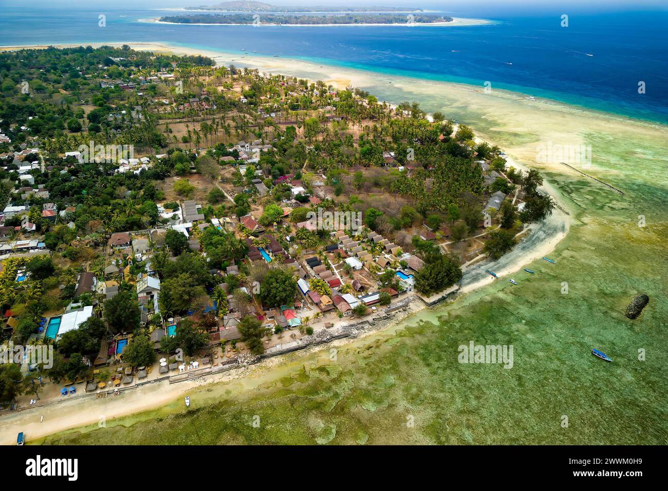Aerial view of a huge coral reef table forming a fringing reef around a ...