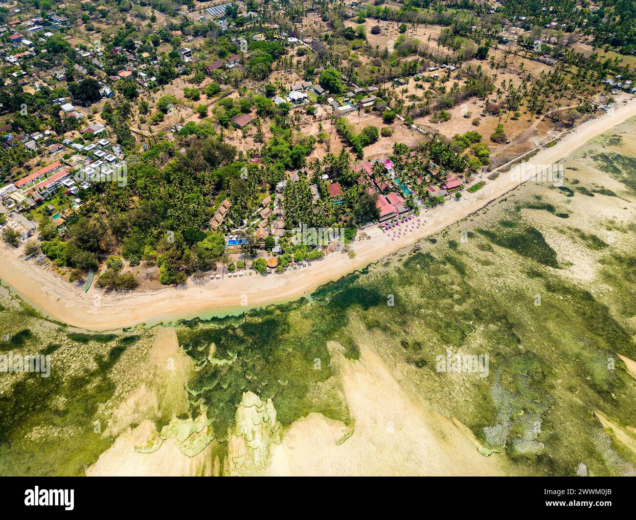 Aerial view of a huge coral reef table forming a fringing reef around a ...