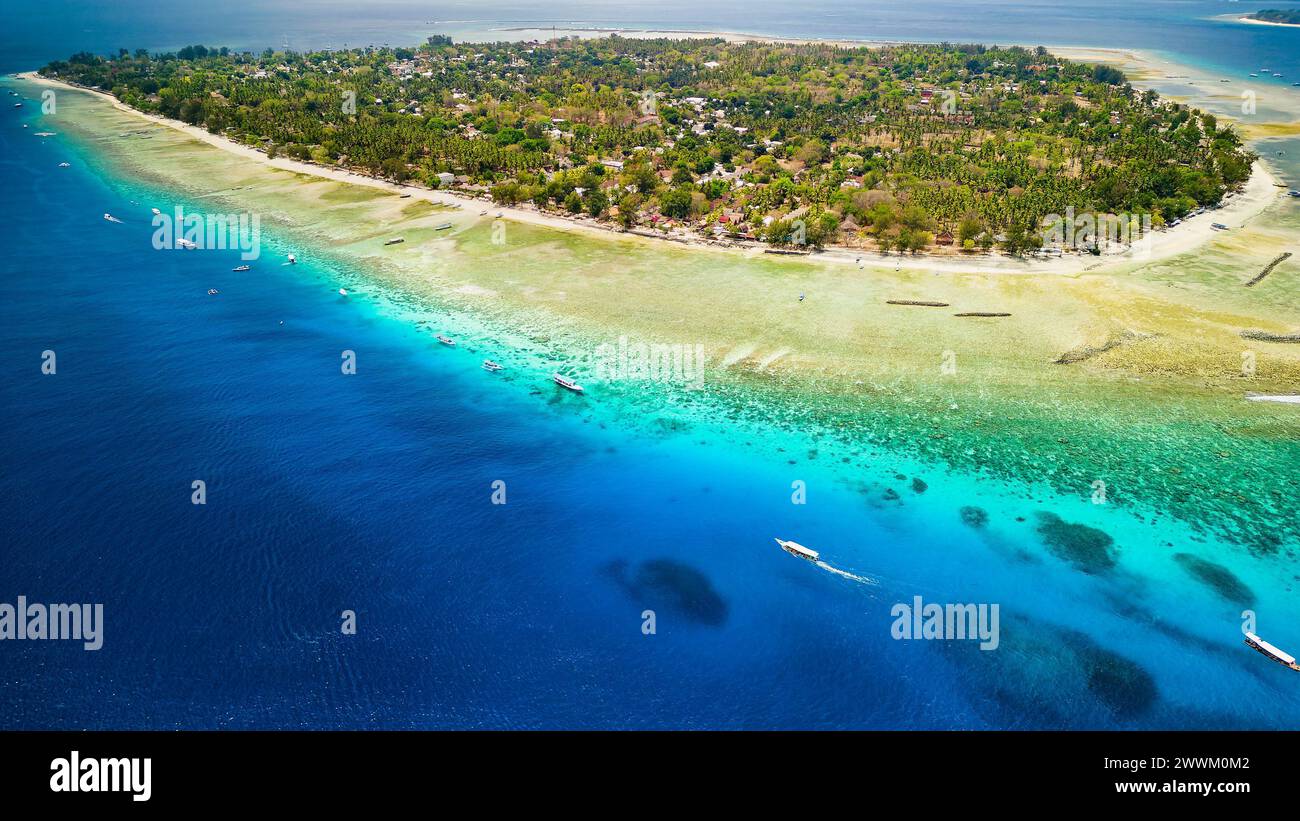 Aerial view of fringing coral reef surrounding a small tropical island ...