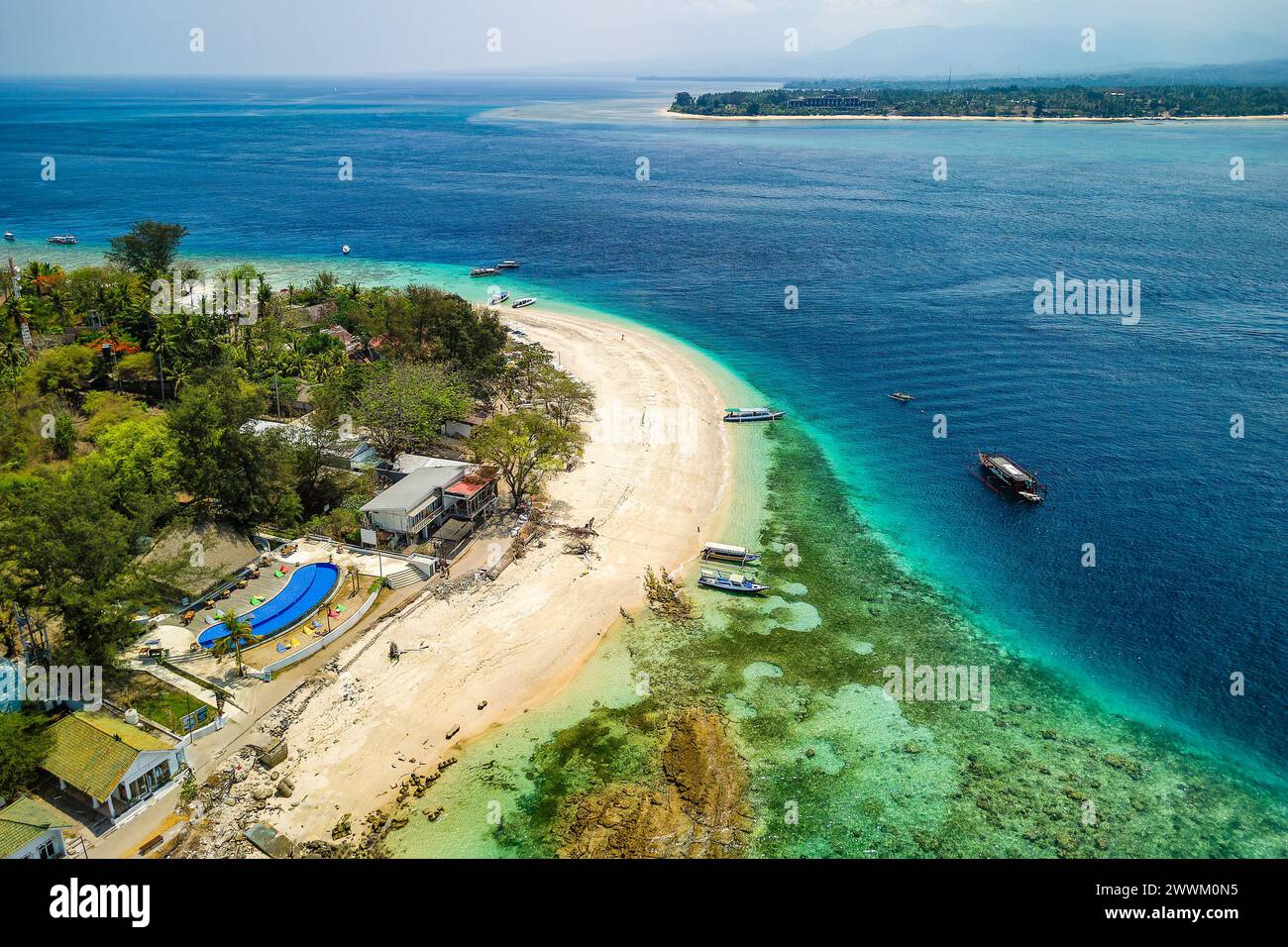 Aerial view of a reef table and coral reef off a tiny tropical island ...