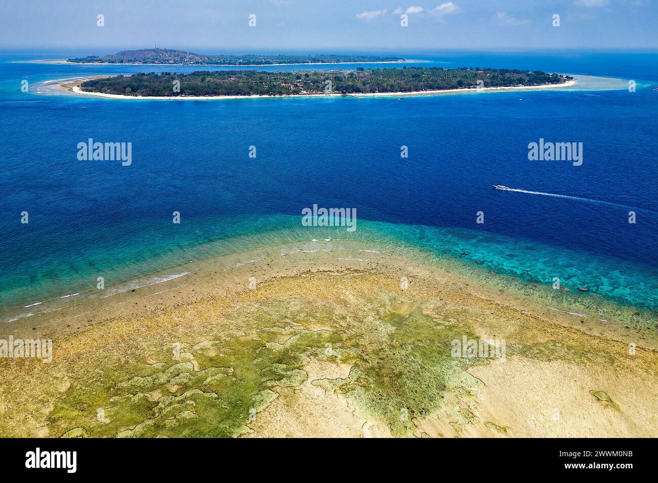Aerial view of a reef table and coral reef off a tiny tropical island ...