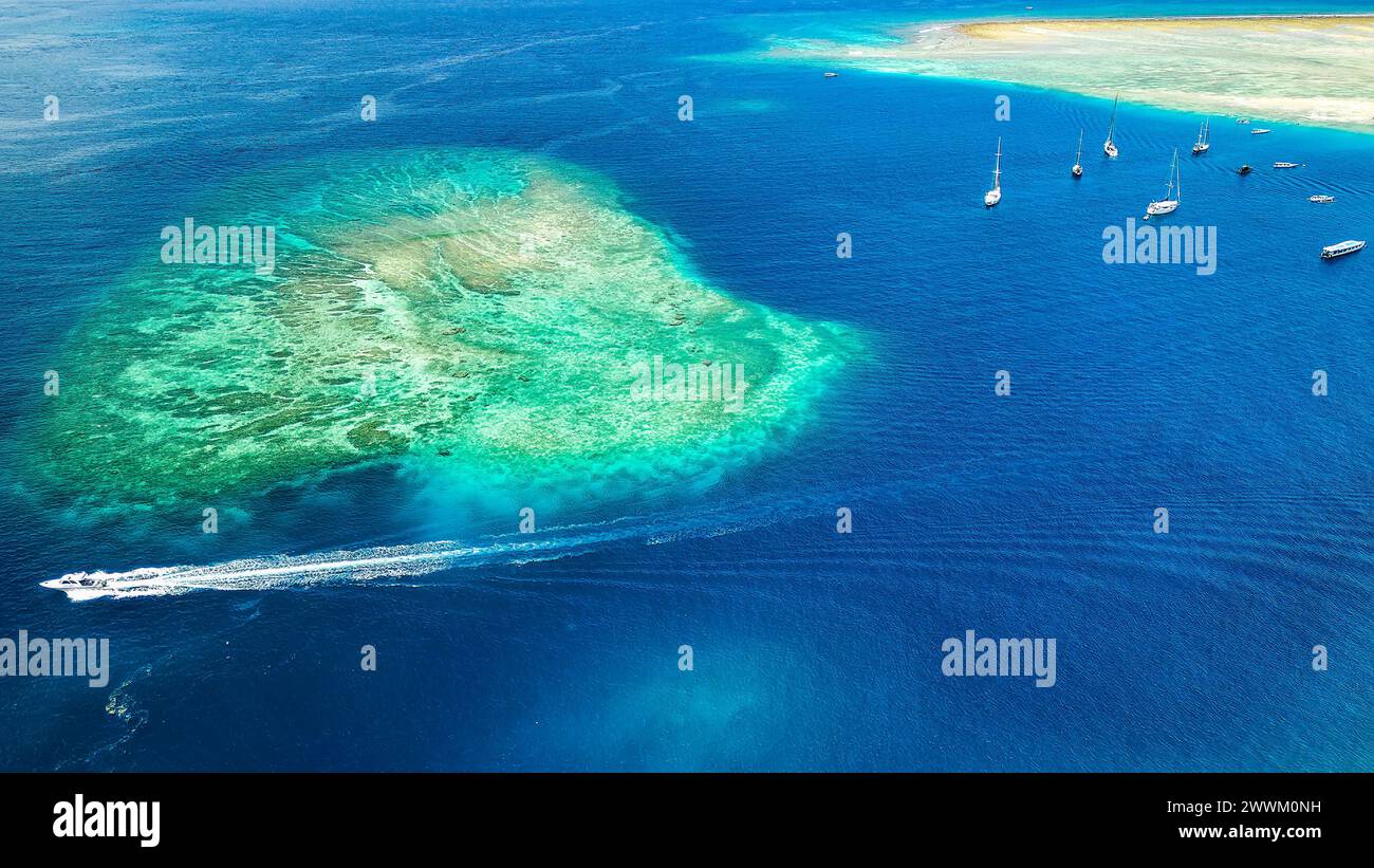 Aerial view of a fringing tropical coral reef around the coastline of a ...