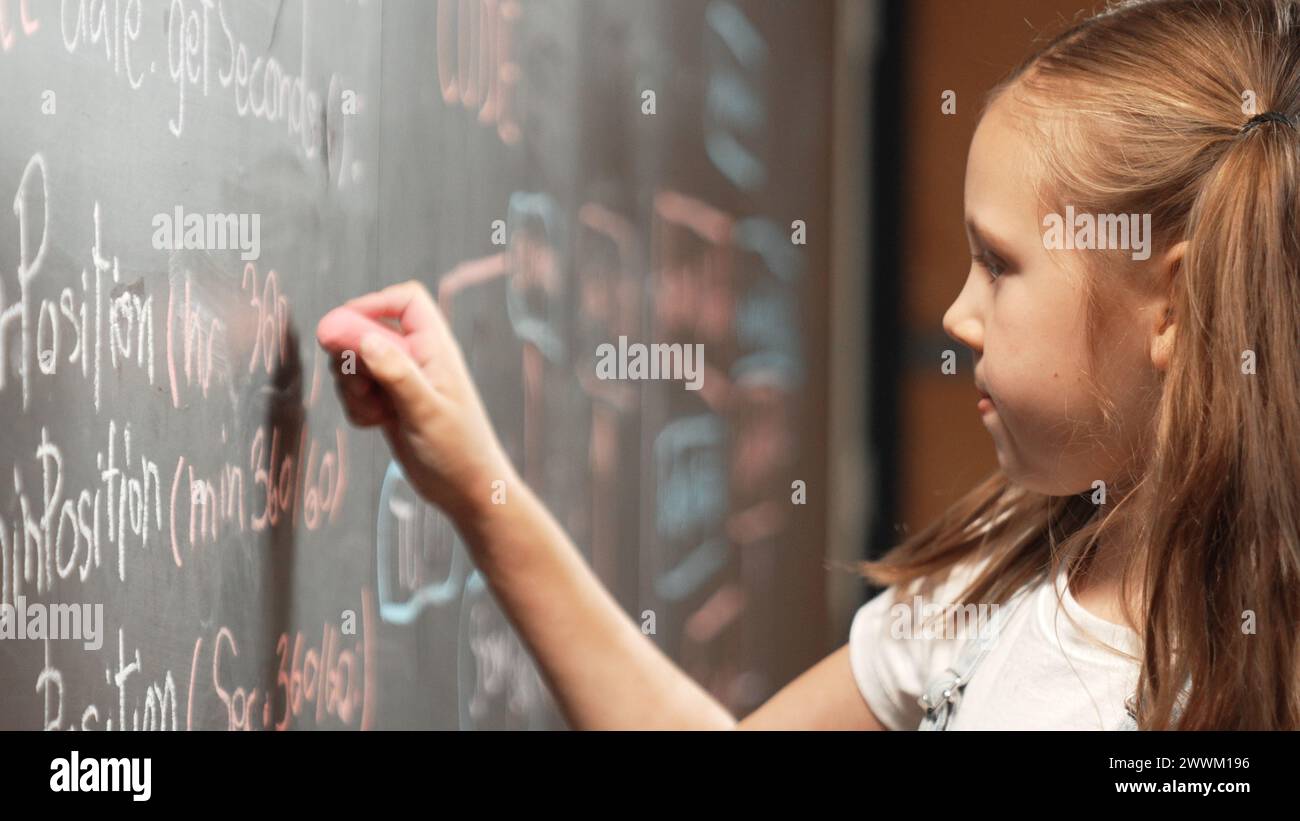 Panorama shot of smart girl writing engineering prompt on blackboard ...