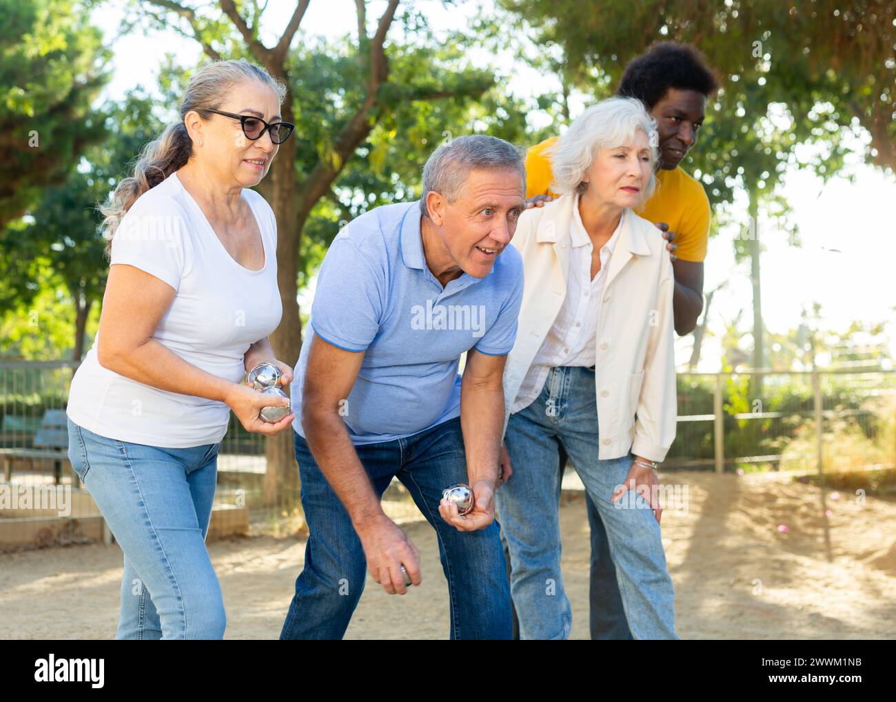 A group of multiracial mature adult people playing patanque game ...