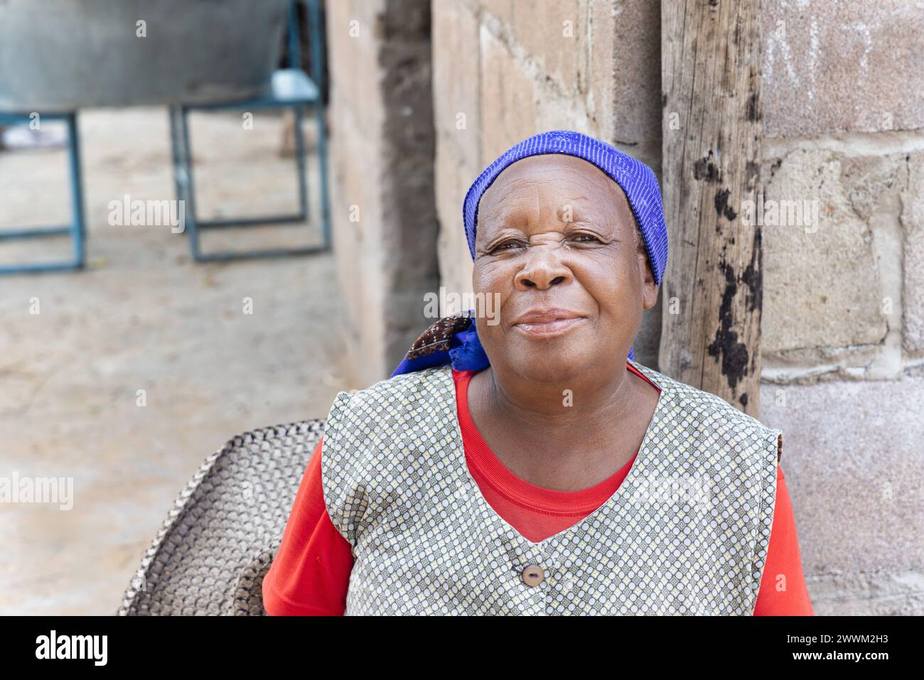 happy village african old woman sitting in her yard, shack in the ...