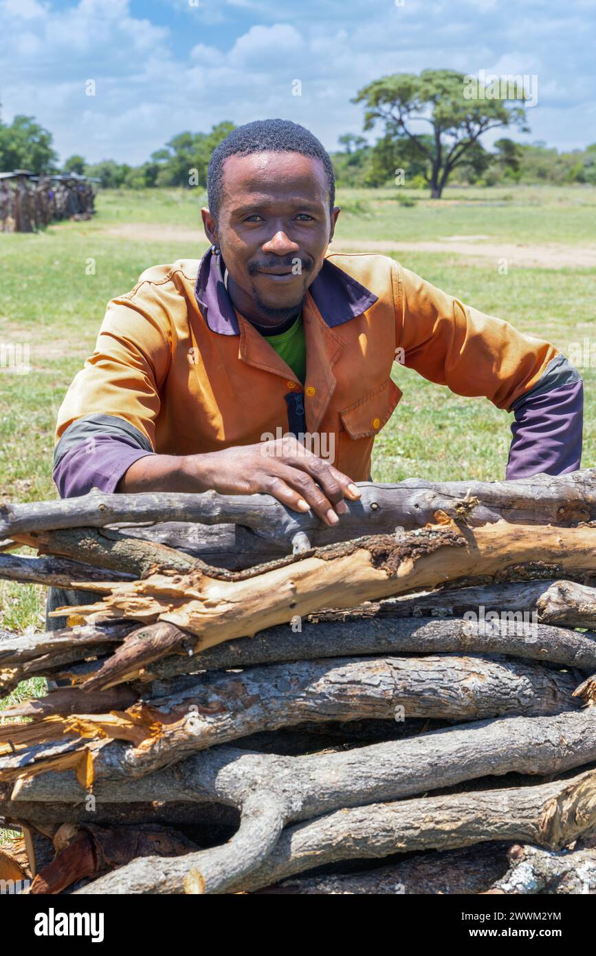 village african man selling cut wood to the customers on the side of ...