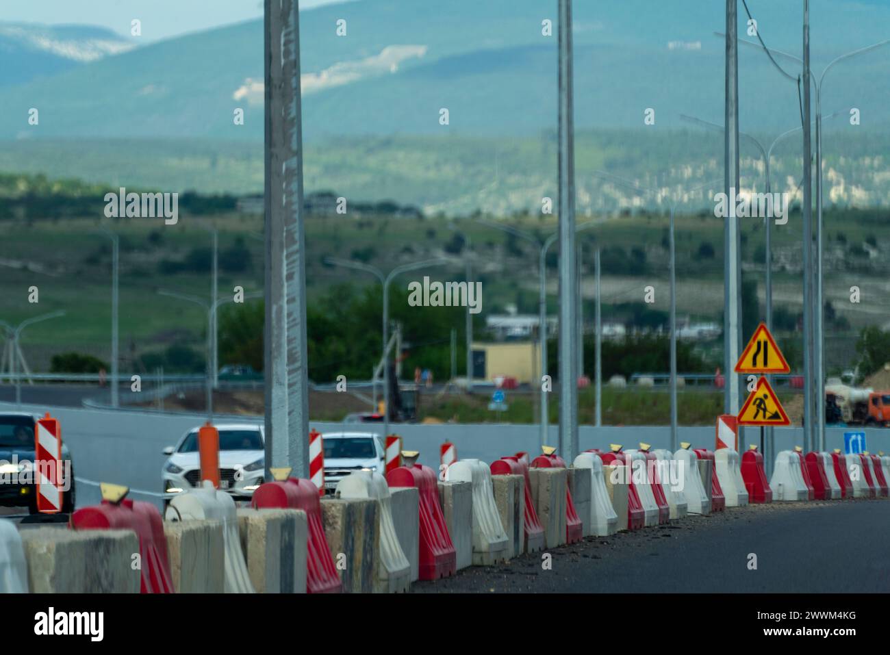 Red, white plastic safety barriers along road. Ensuring road safety ...