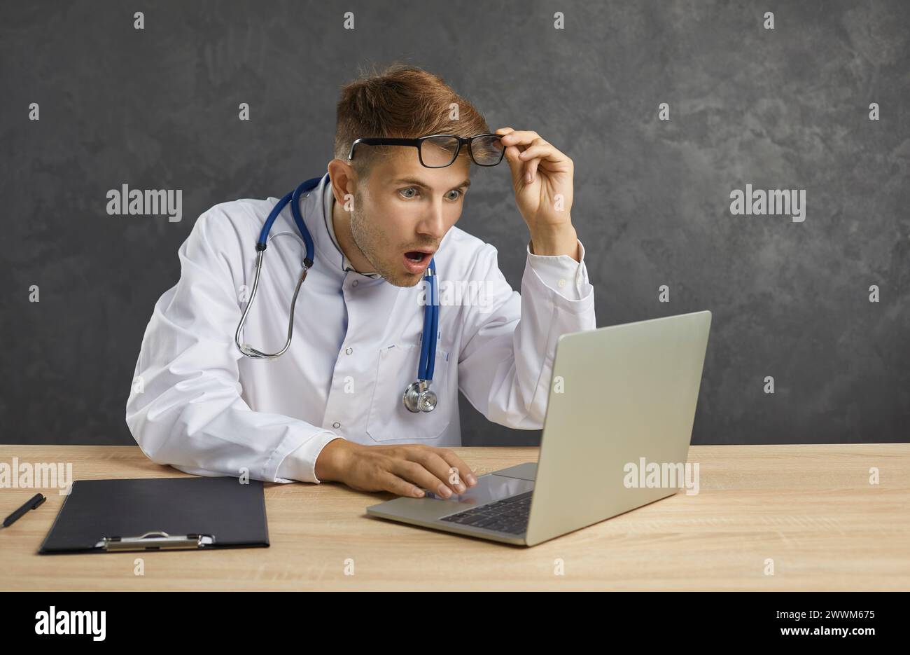 Embarrassed male doctor with a shocked and confused face looks at the ...