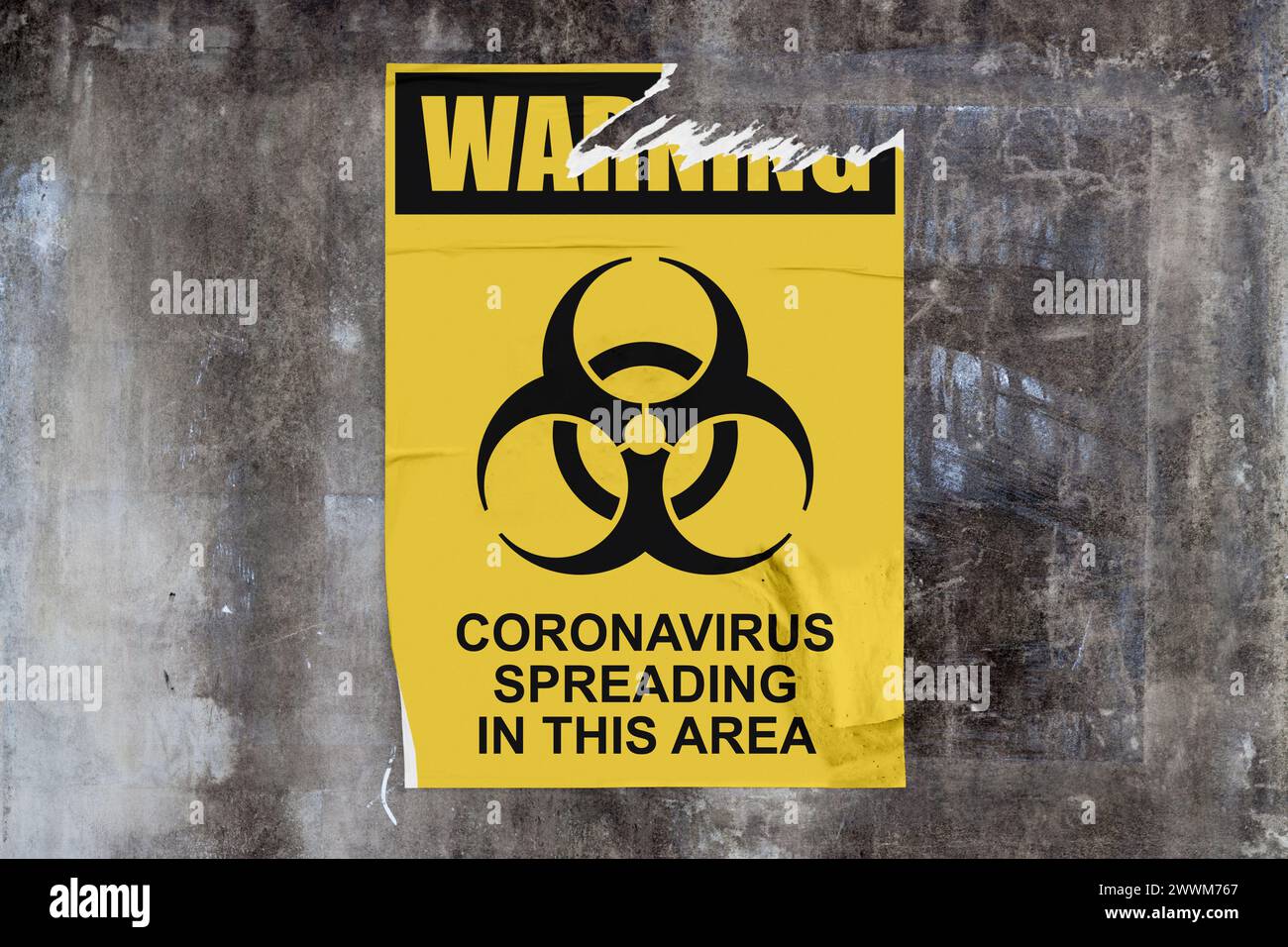 Full-frame weathered concrete wall with a torn yellow poster in the ...