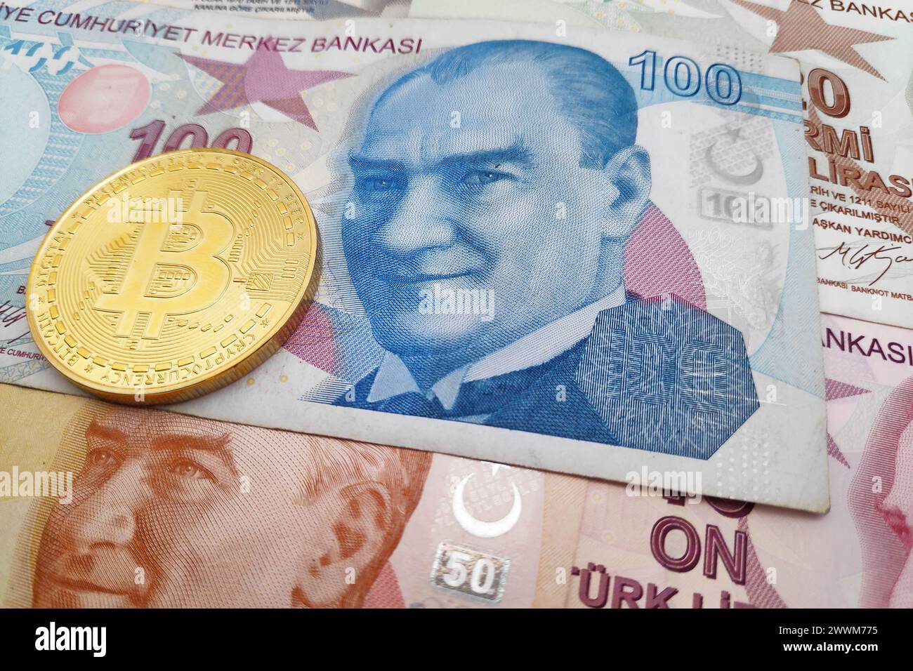 Close-up on a golden Bitcoin coin on top of a stack of Turkish lira ...