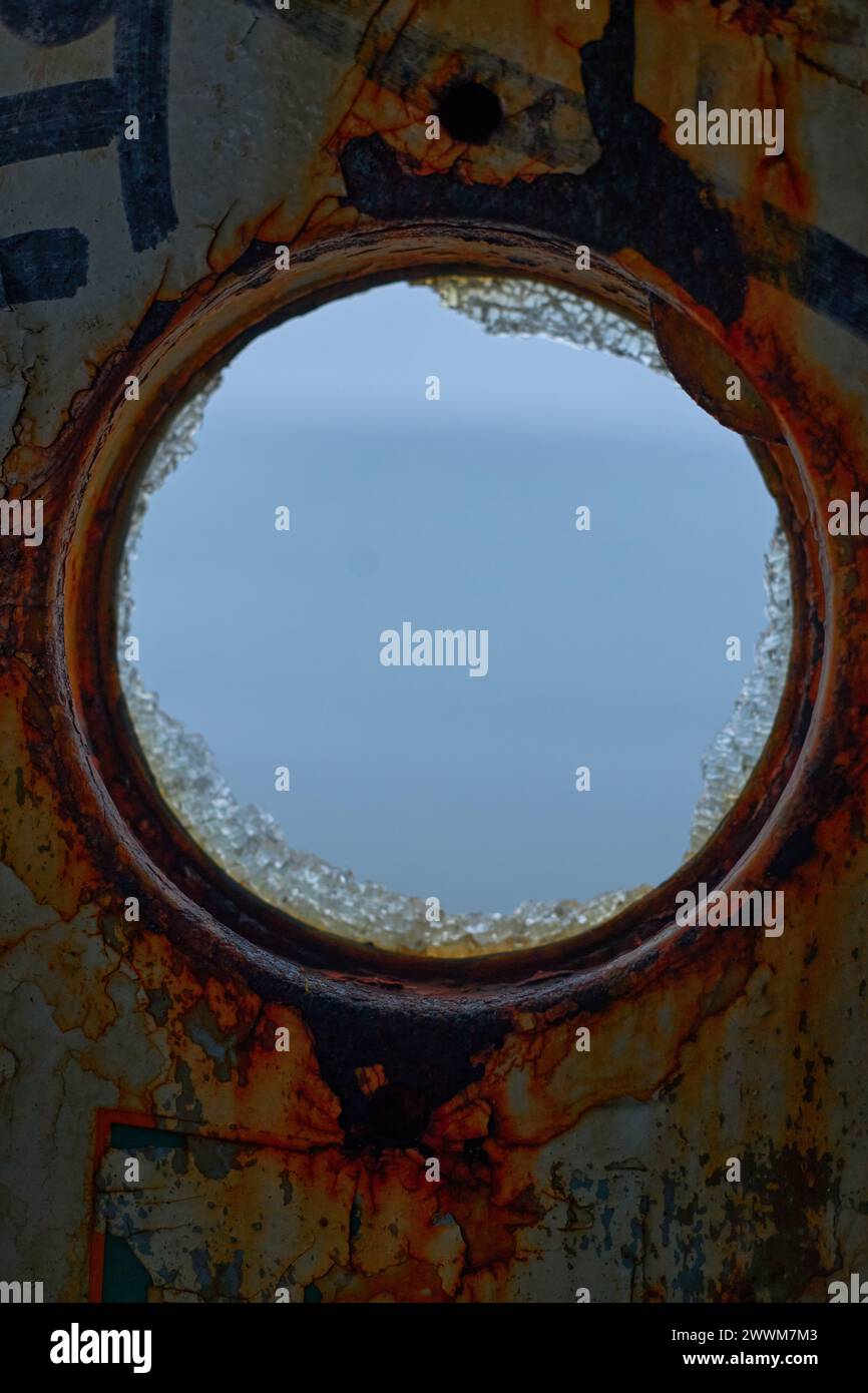 View of sea through the round window of an old, rusted ships hull Stock ...