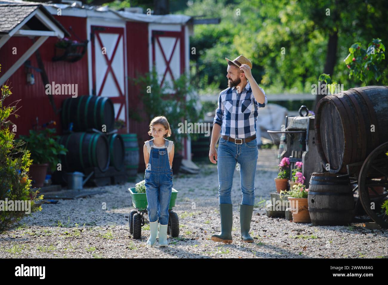 Father and young daughter walking across family farm. Concept of ...