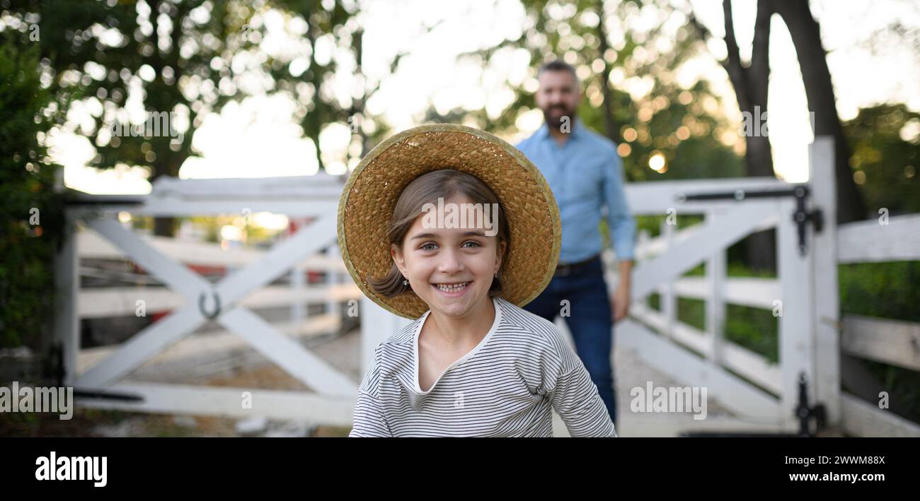 Portrait of farmer family, father and young daughter standing on wooden ...
