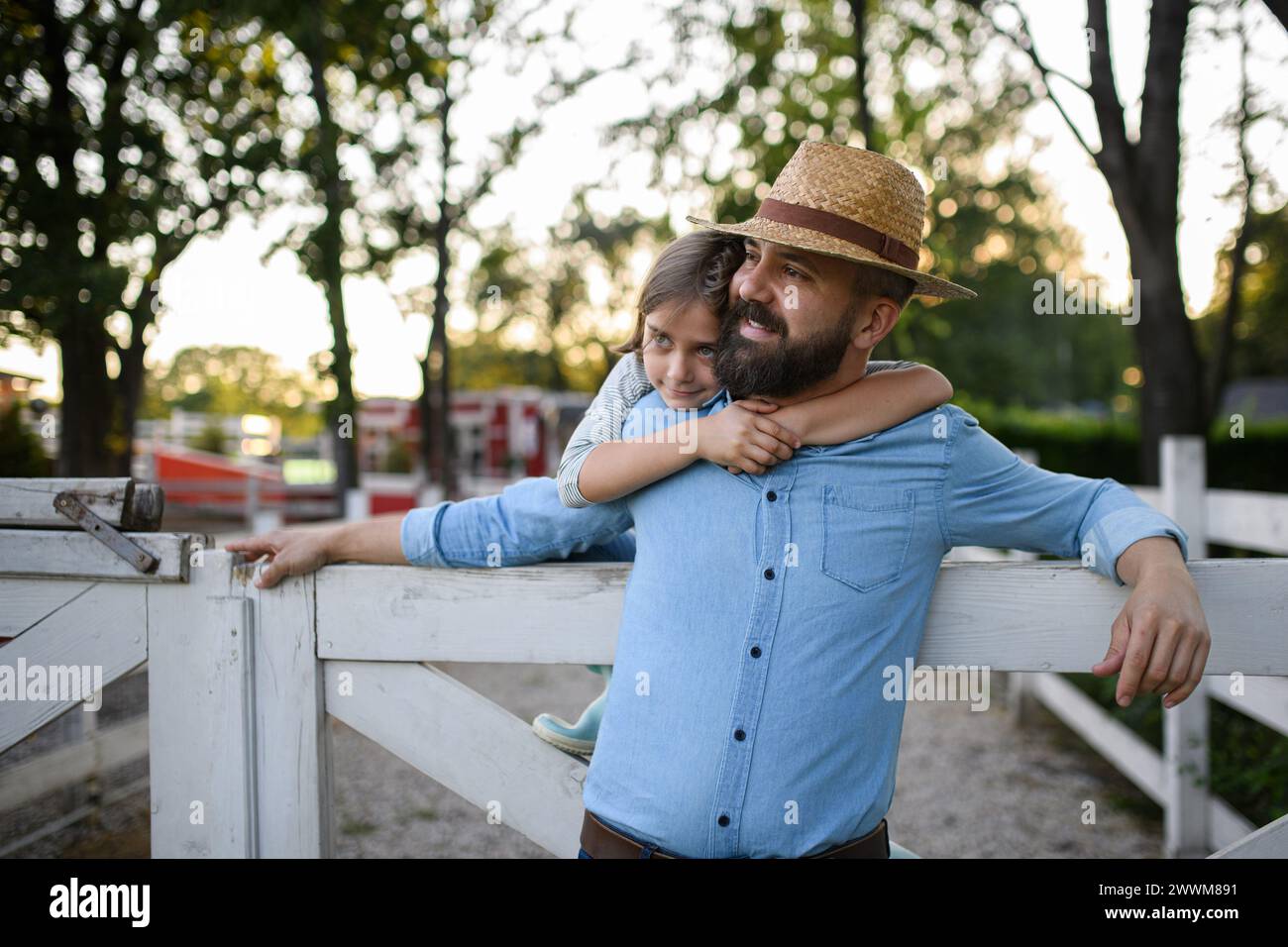 Portrait of farmer family, father and young daughter standing on wooden ...