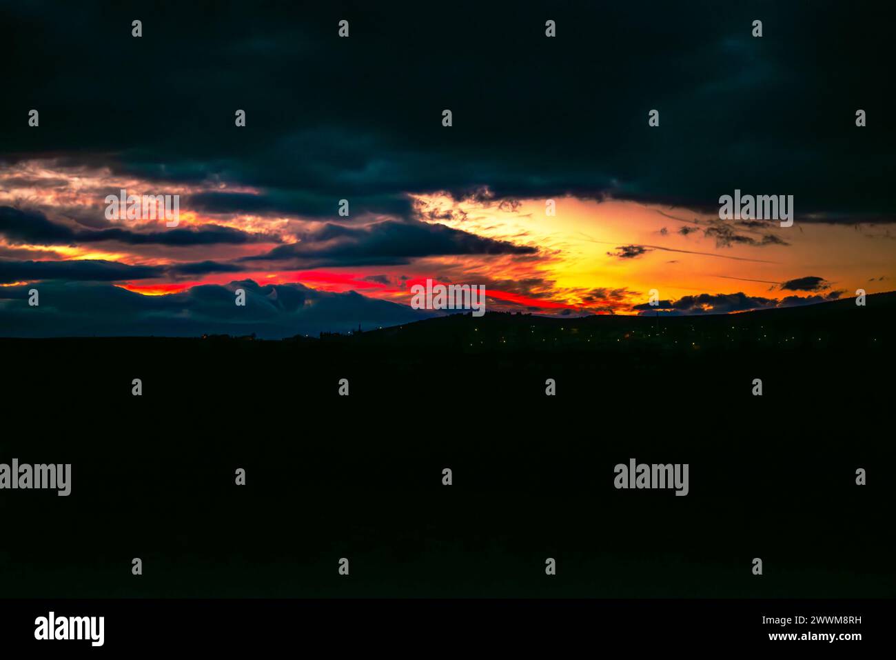 In the tranquil twilight, a red sunset bathes the sky in fiery hues ...