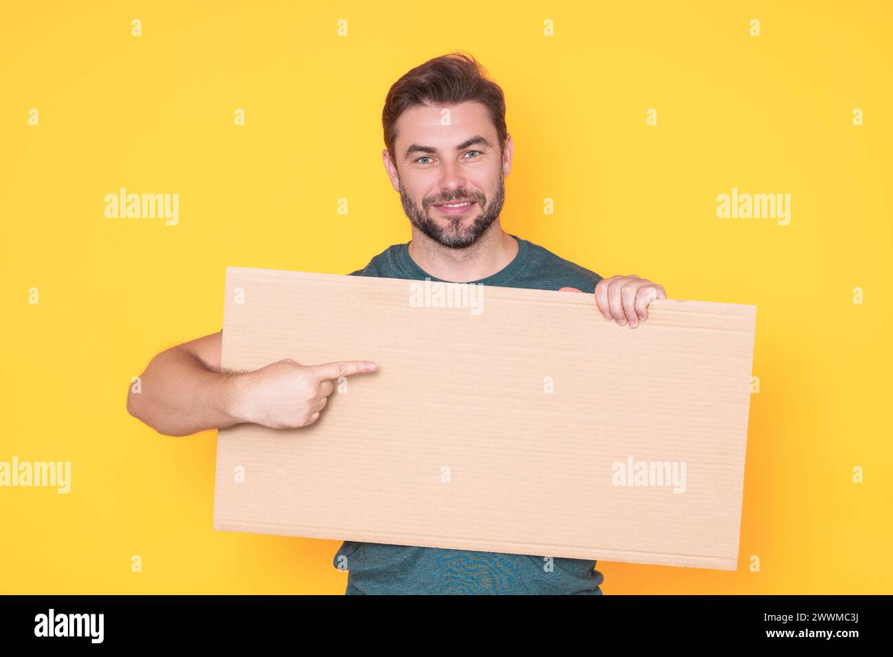 Man in studio showing promo blank board pointing finger on sign board ...