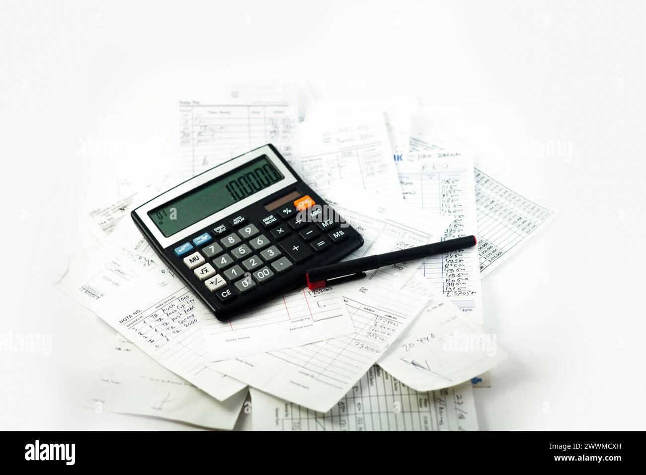 Calculator, bills and pen in the white background Stock Photo - Alamy