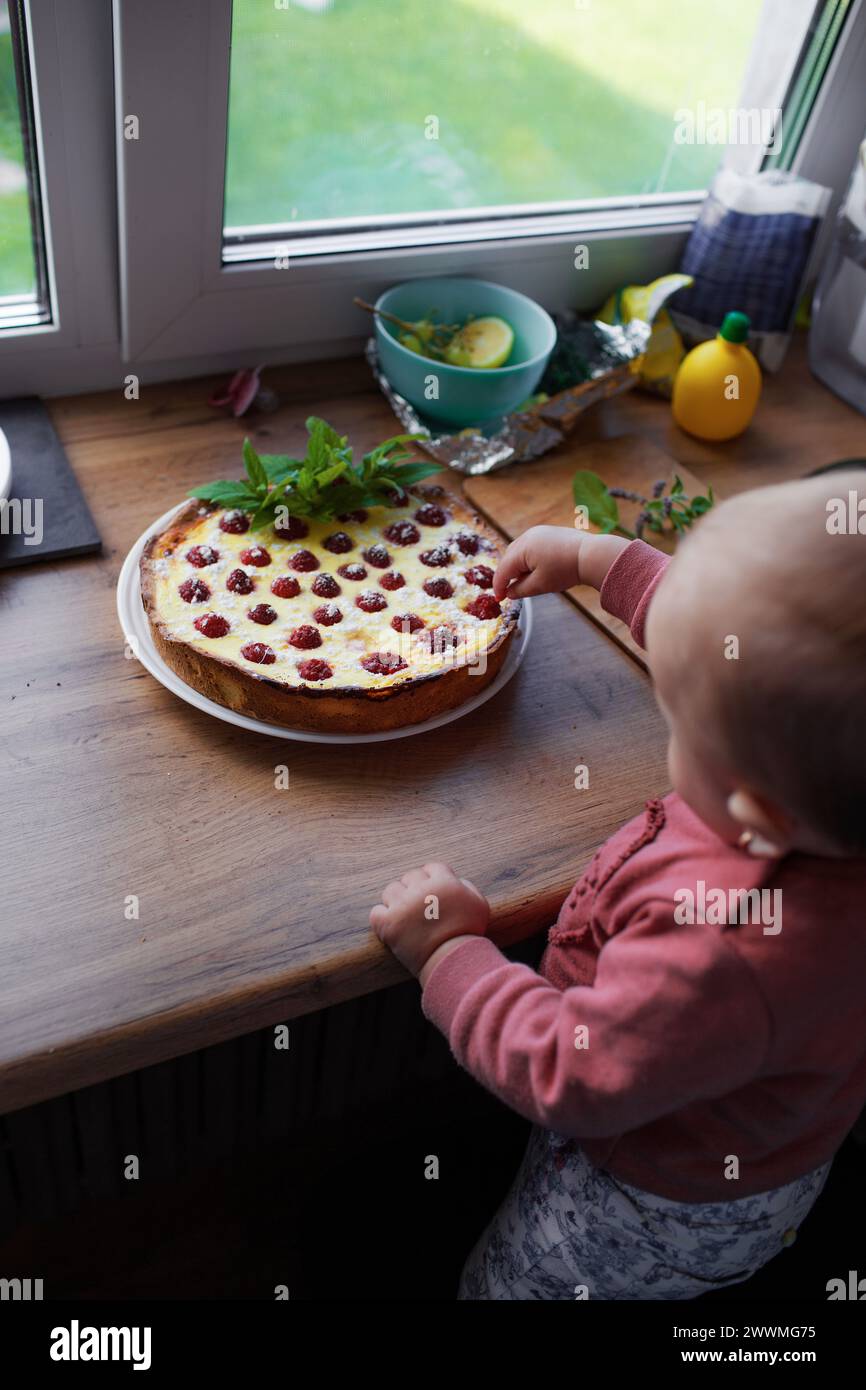 A cute little girl tries a berry cake on her first birthday Stock Photo ...