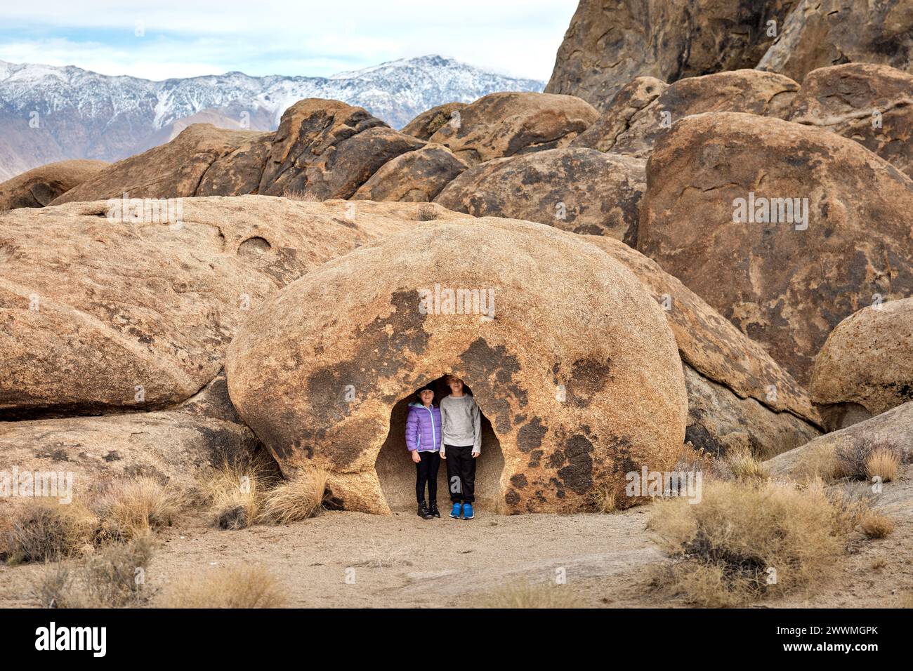 Brother and sister standing under rock formation at Alabama Hills Stock ...