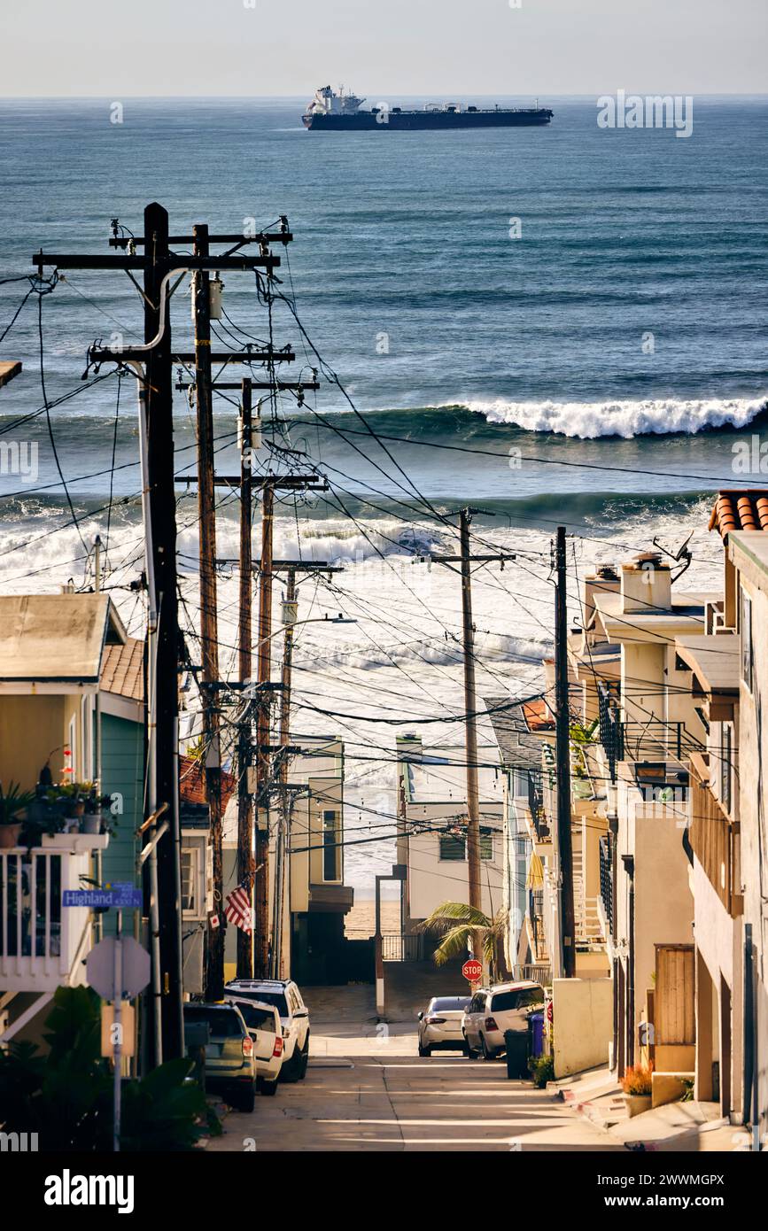 Power lines over houses in alley with sea in background Stock Photo - Alamy