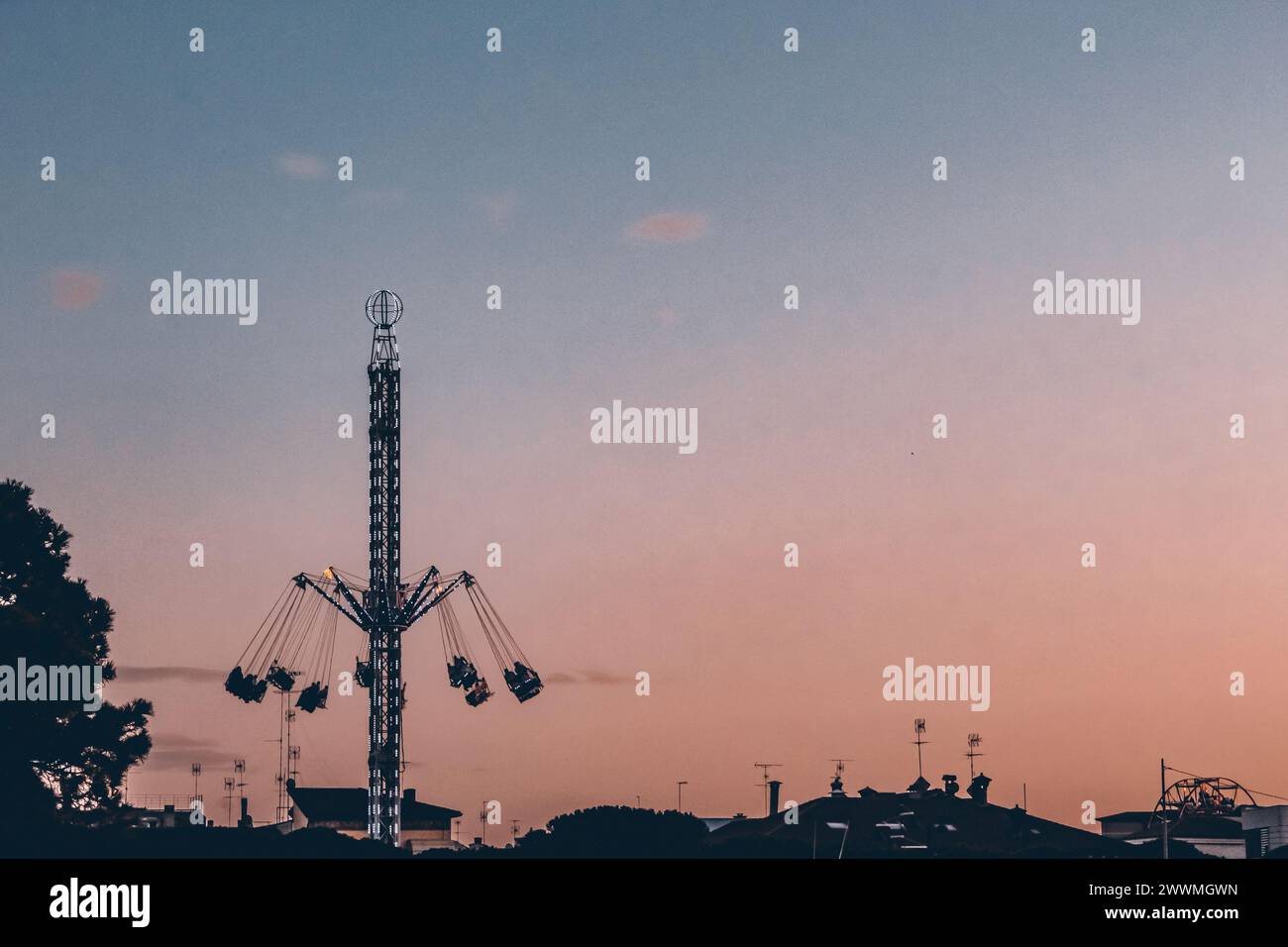 giant carousel flying in the background at pink sunset Stock Photo - Alamy