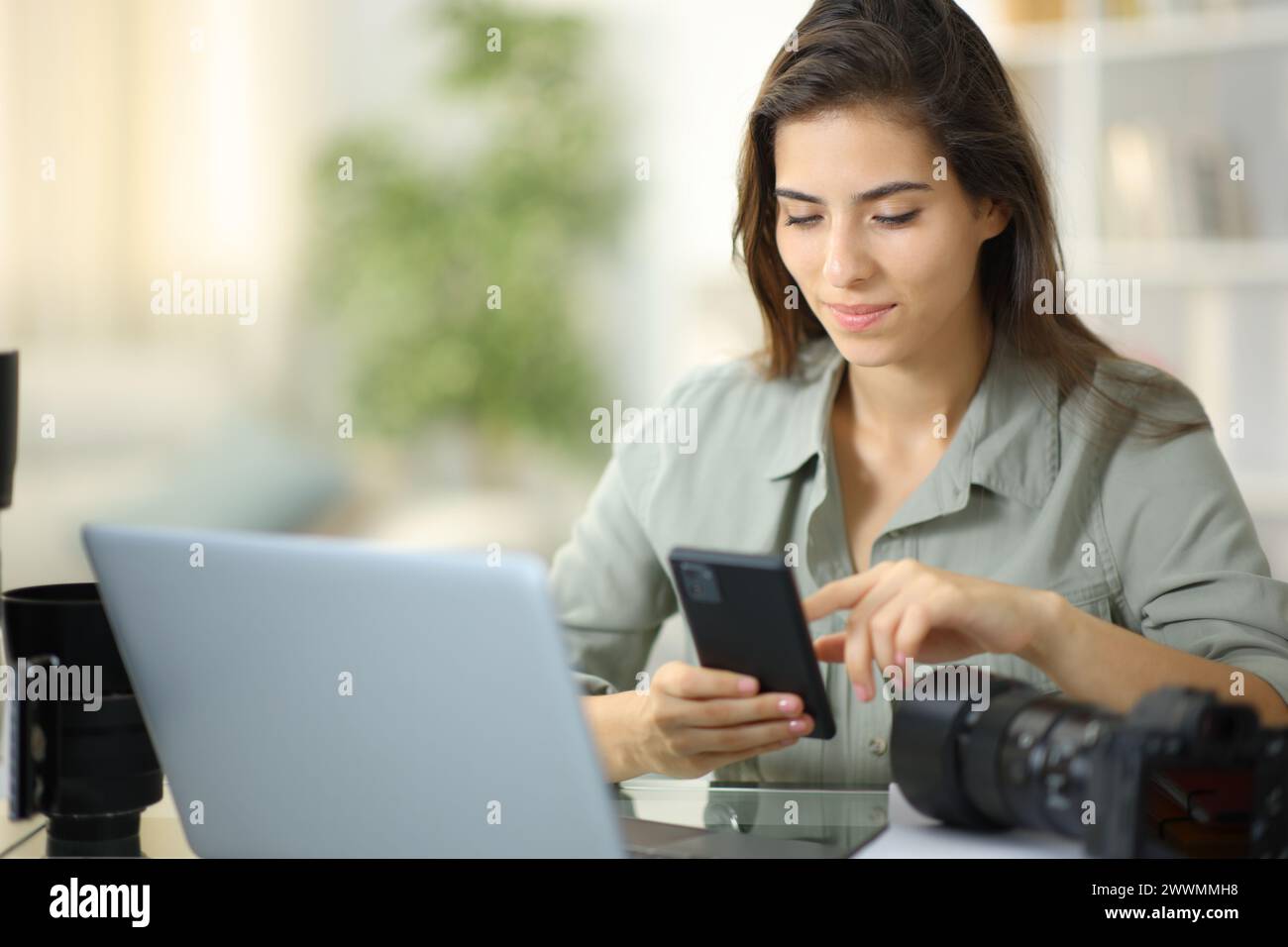 Photographer at home checking phone content Stock Photo - Alamy