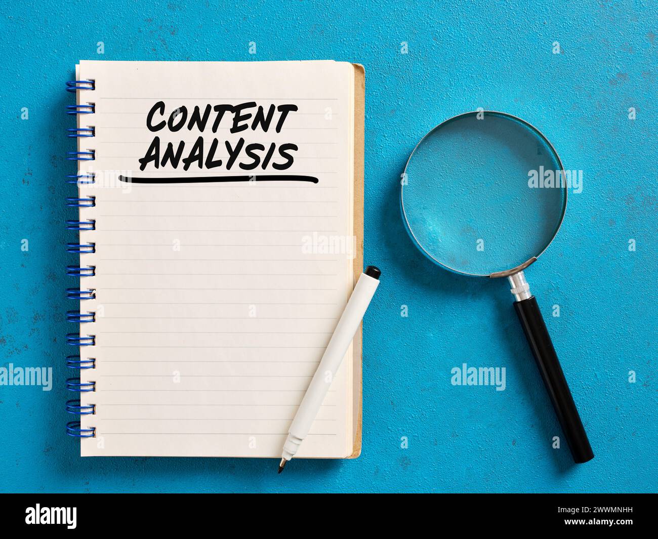 The word content analysis handwritten on a notebook with a magnifying ...