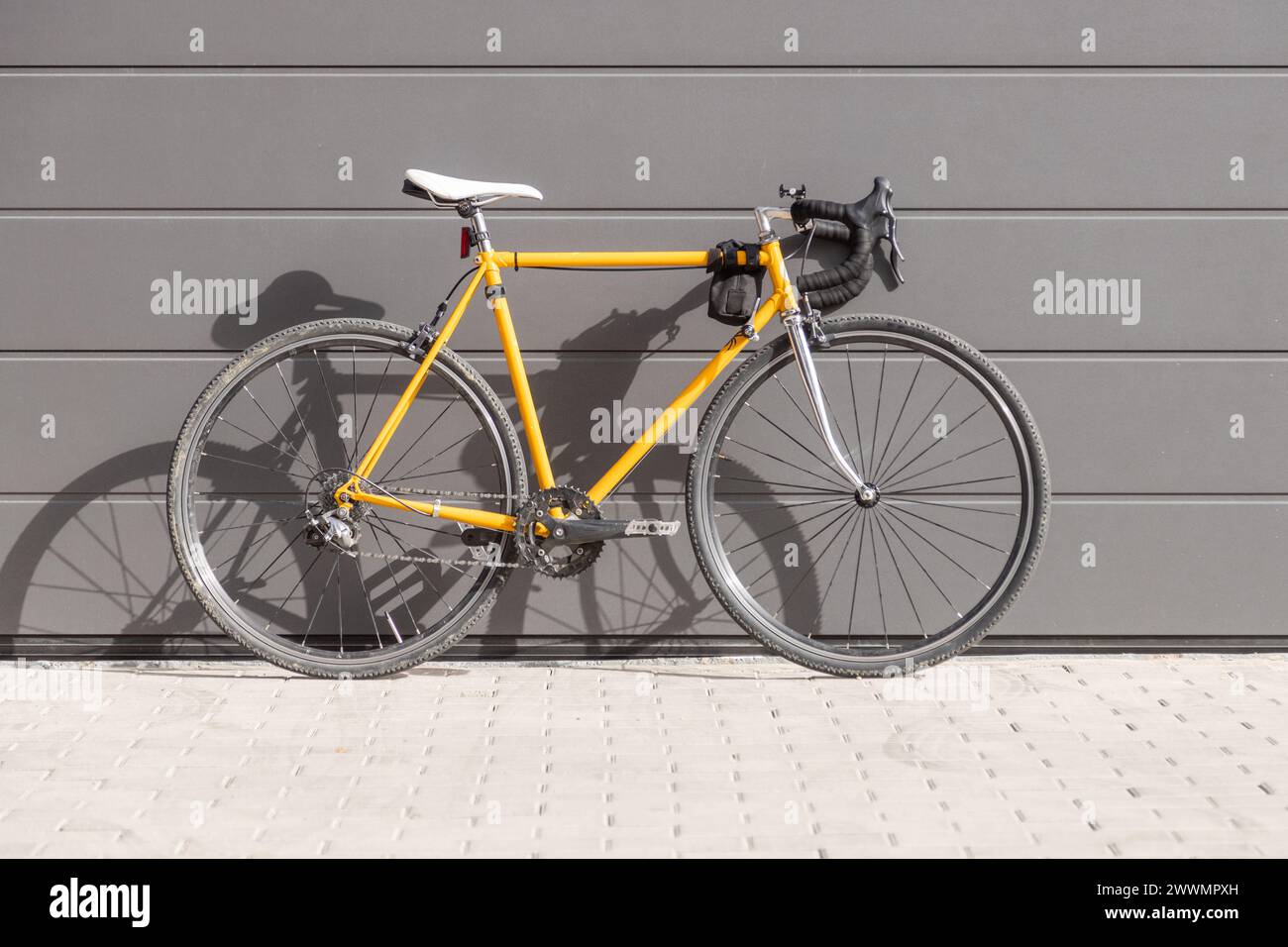 vintage yellow fixie road bike stacked on a gray wall Stock Photo - Alamy