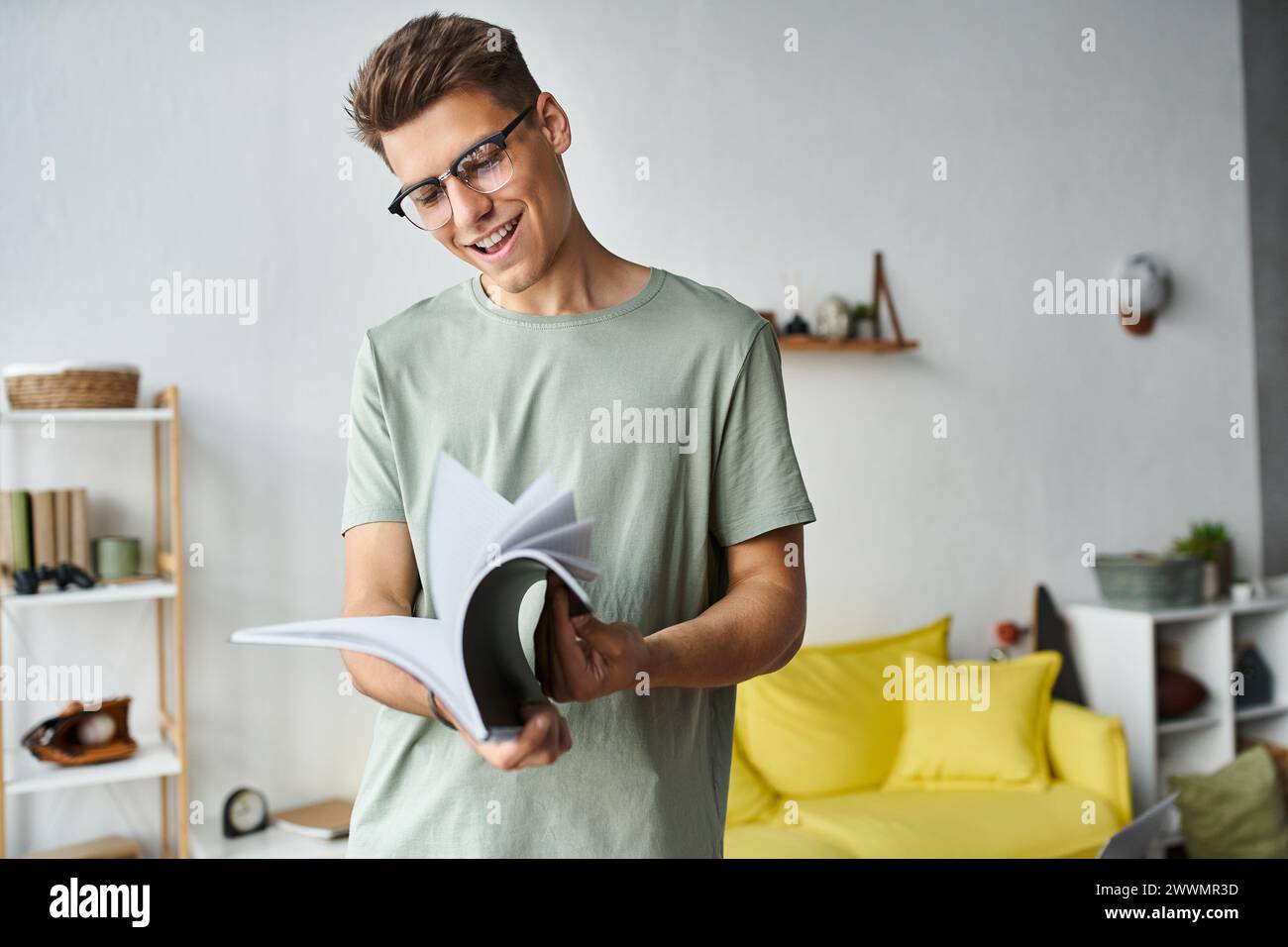 happy and charming guy with brown hair and vision glasses in living ...